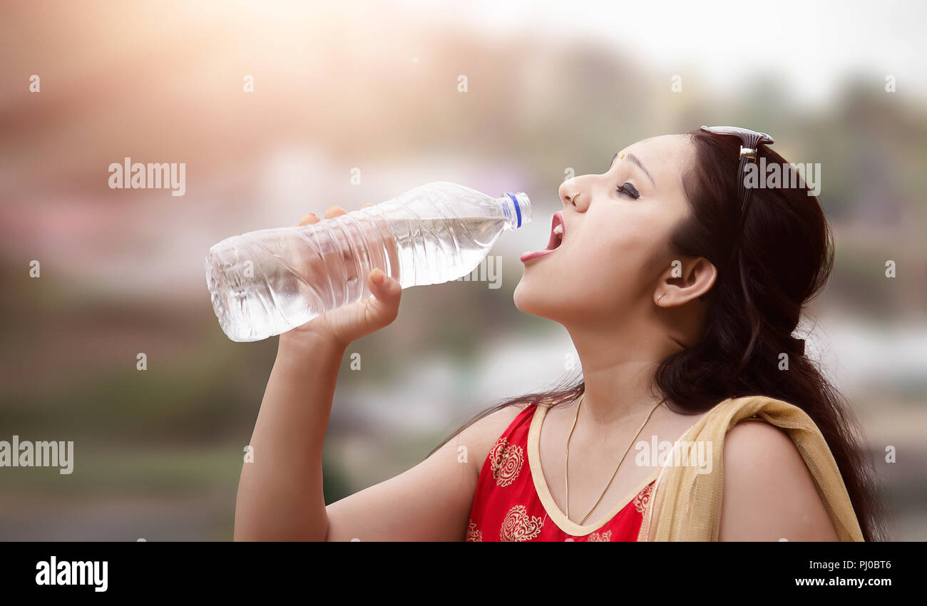 Beautiful Indian Woman drinking water from Bottle Stock Photo - Alamy