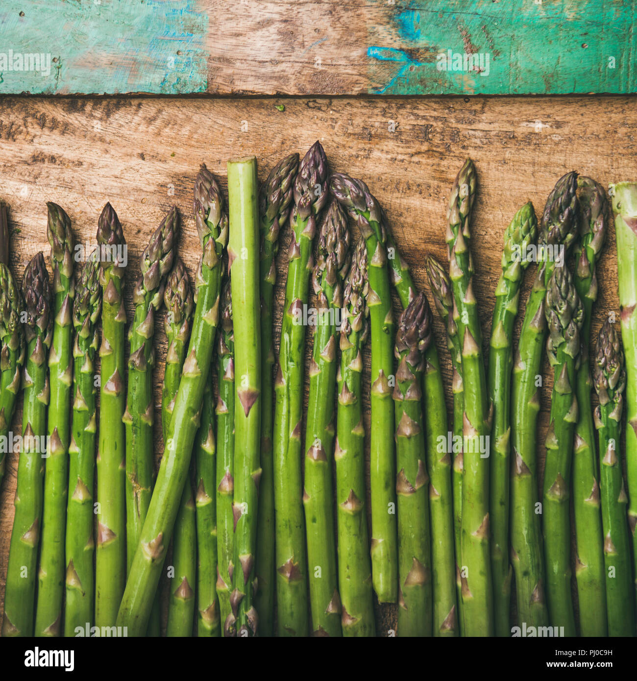 Raw green asparagus in row over rustic background, square crop Stock ...