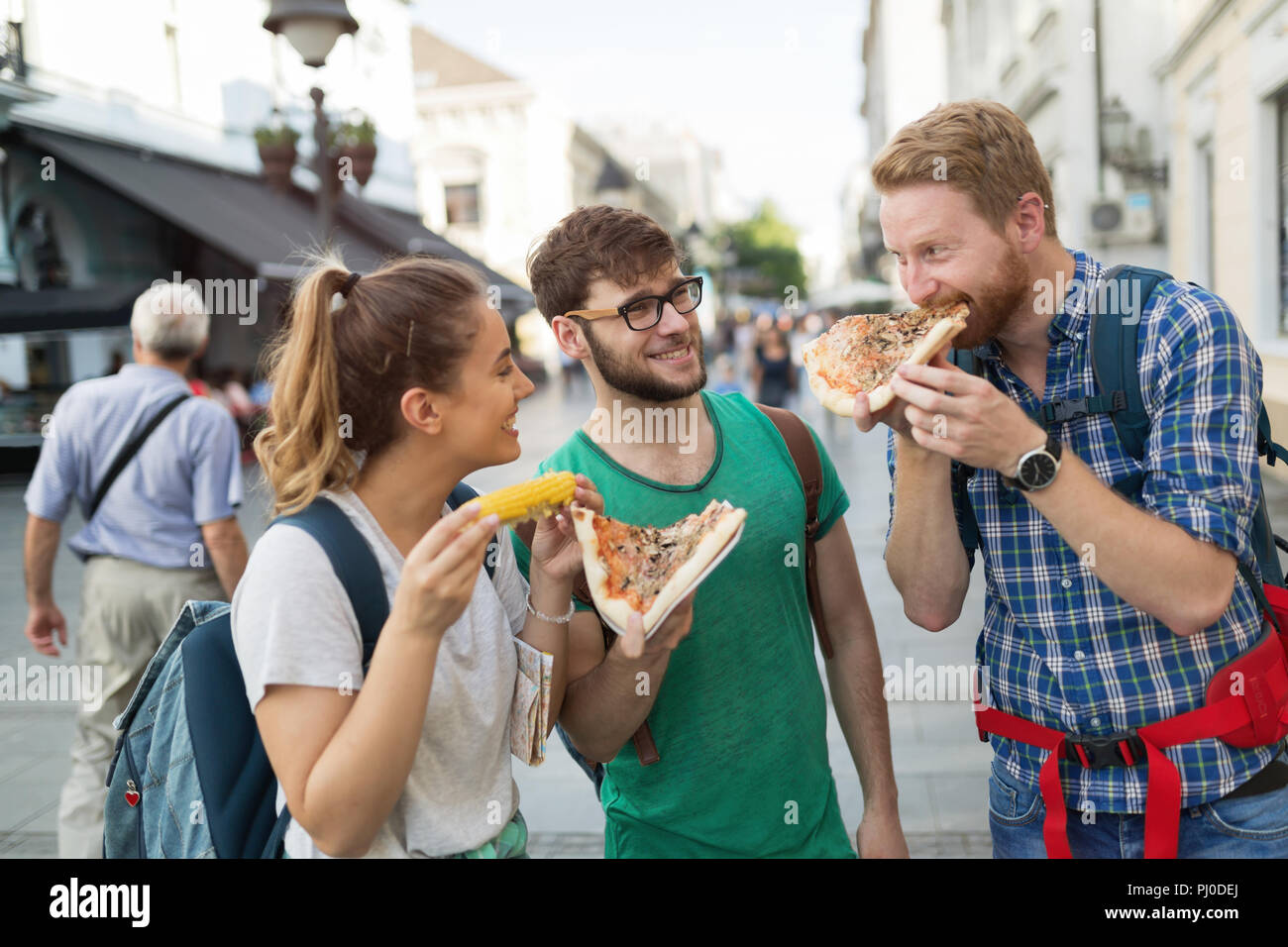 Happy people eating fast food in city Stock Photo - Alamy
