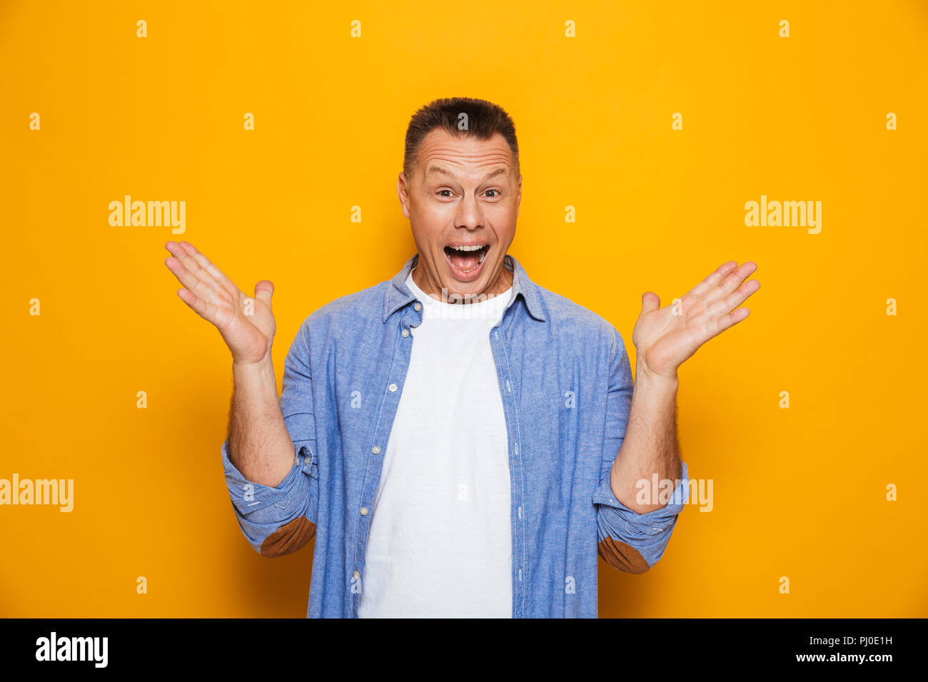 Portrait of a happy middle aged man celebrating success isolated over ...