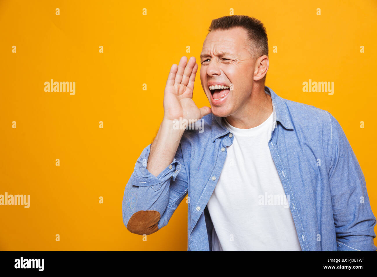 Portrait of a cheerful middle aged man shouting loud isolated over ...