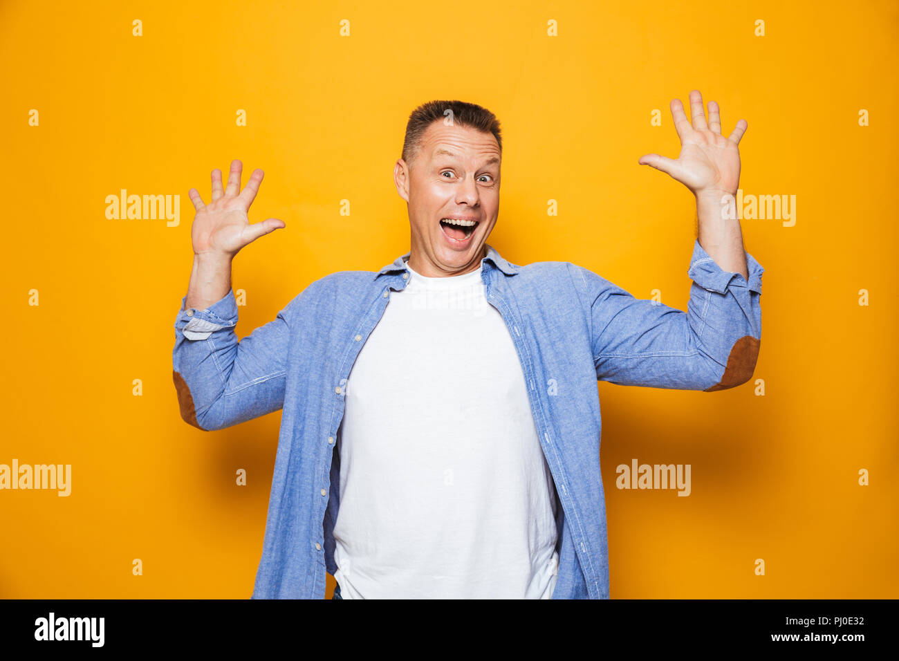Portrait of a cheerful middle aged man celebrating success isolated ...