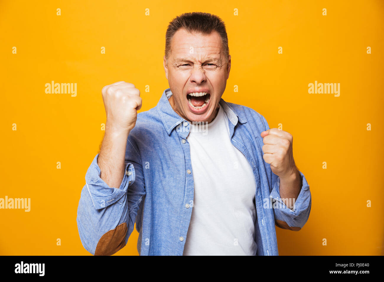 Portrait of a happy middle aged man celebrating success isolated over ...