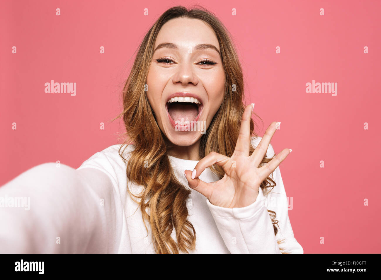 Portrait of a happy young woman taking selfie with outstretched hand ...