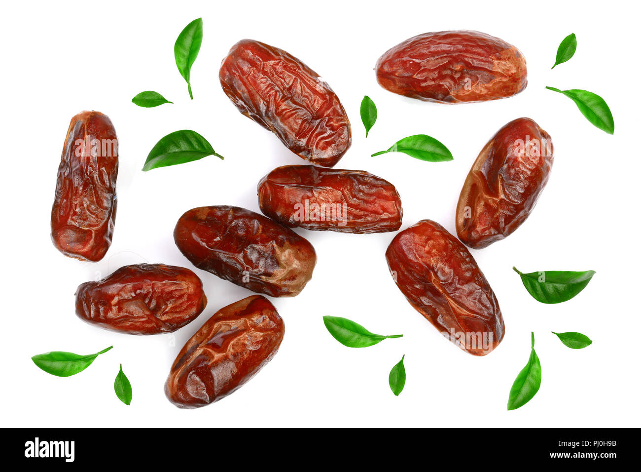 dry dates decorated with leaves isolated on white background. Top view ...