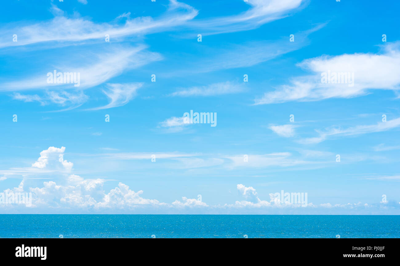 Vast sky space with summer clouds above the stripe of the sea with the ...