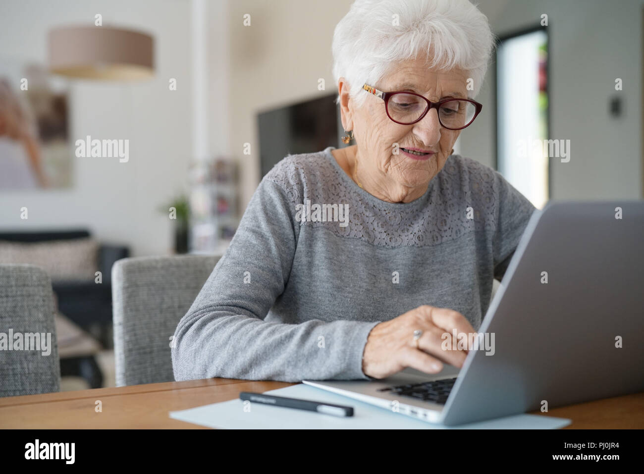 Old woman at home using laptop computer Stock Photo - Alamy