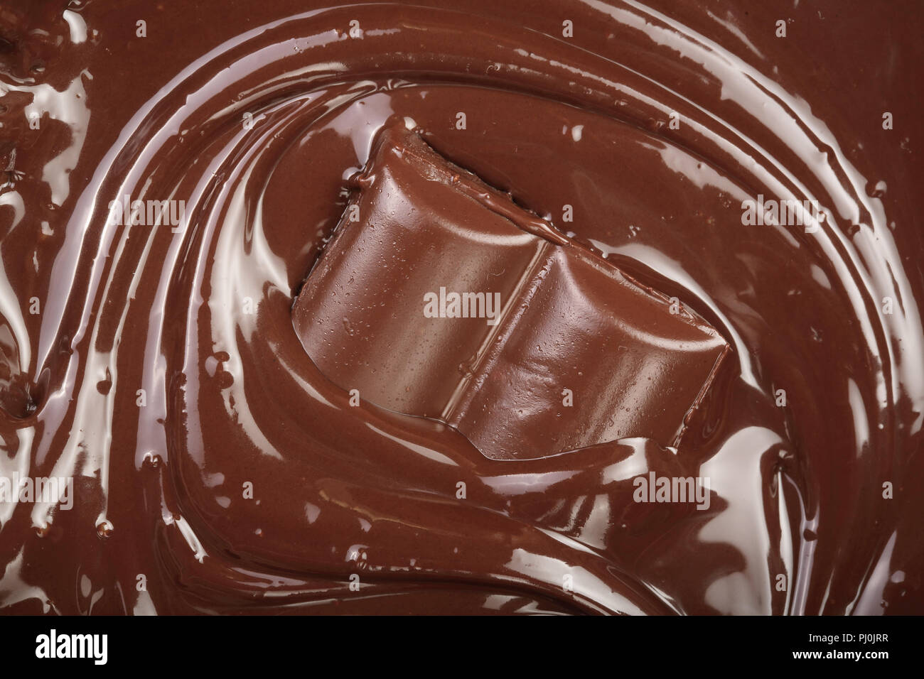 Melted chocolate and pieces of chocolate bar as a background closeup ...