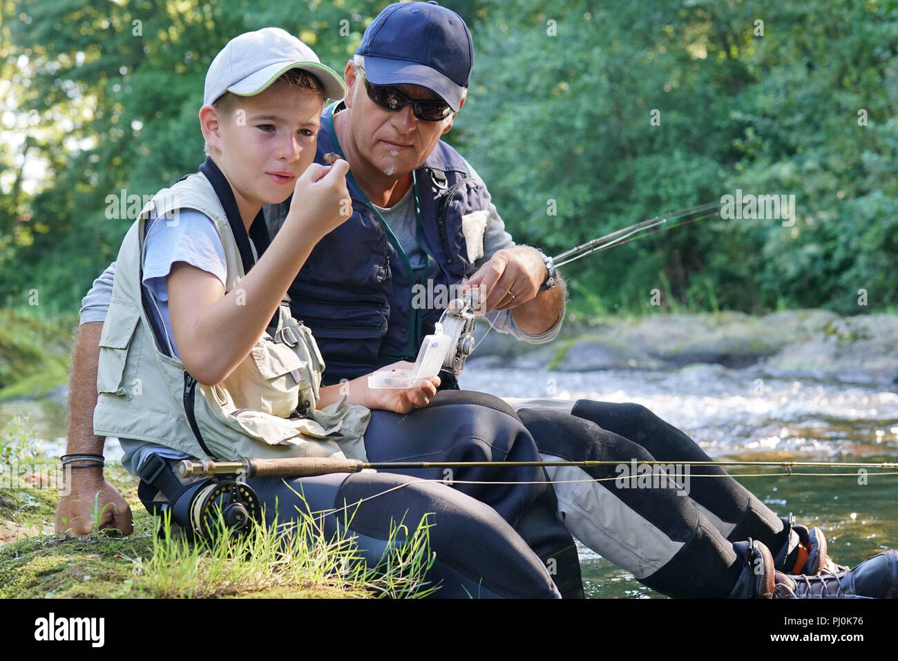 Dad helping son to choose flies for fishing line Stock Photo - Alamy