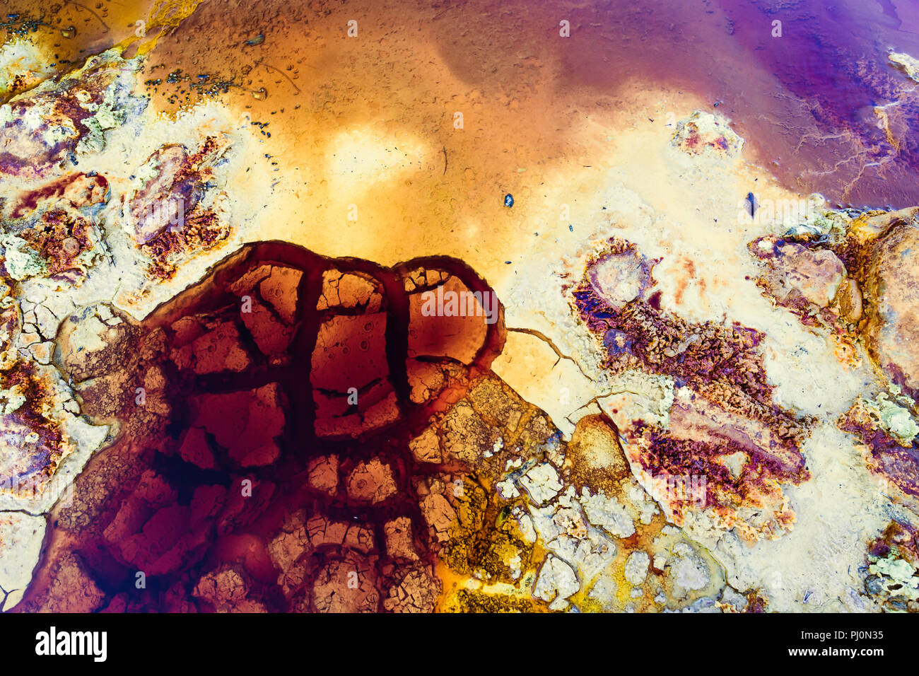 Colorful rocks on cracked ground in the river with red water Stock ...