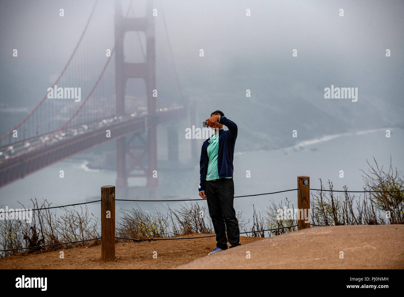 A man takes a selfie with the Golden Gate suspension bridge in the ...
