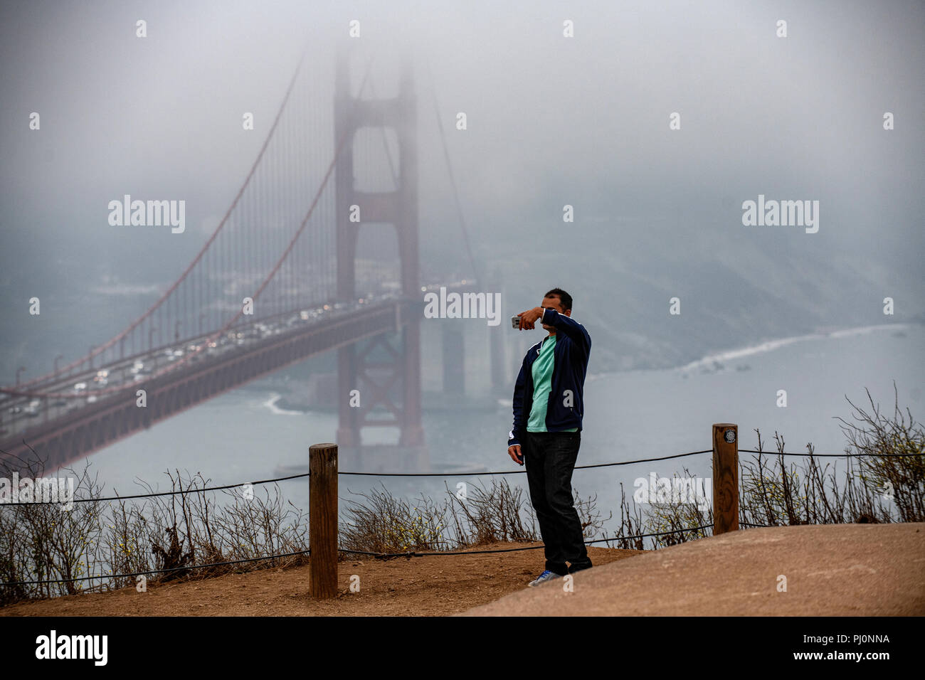 A man takes a selfie with the Golden Gate suspension bridge in the ...