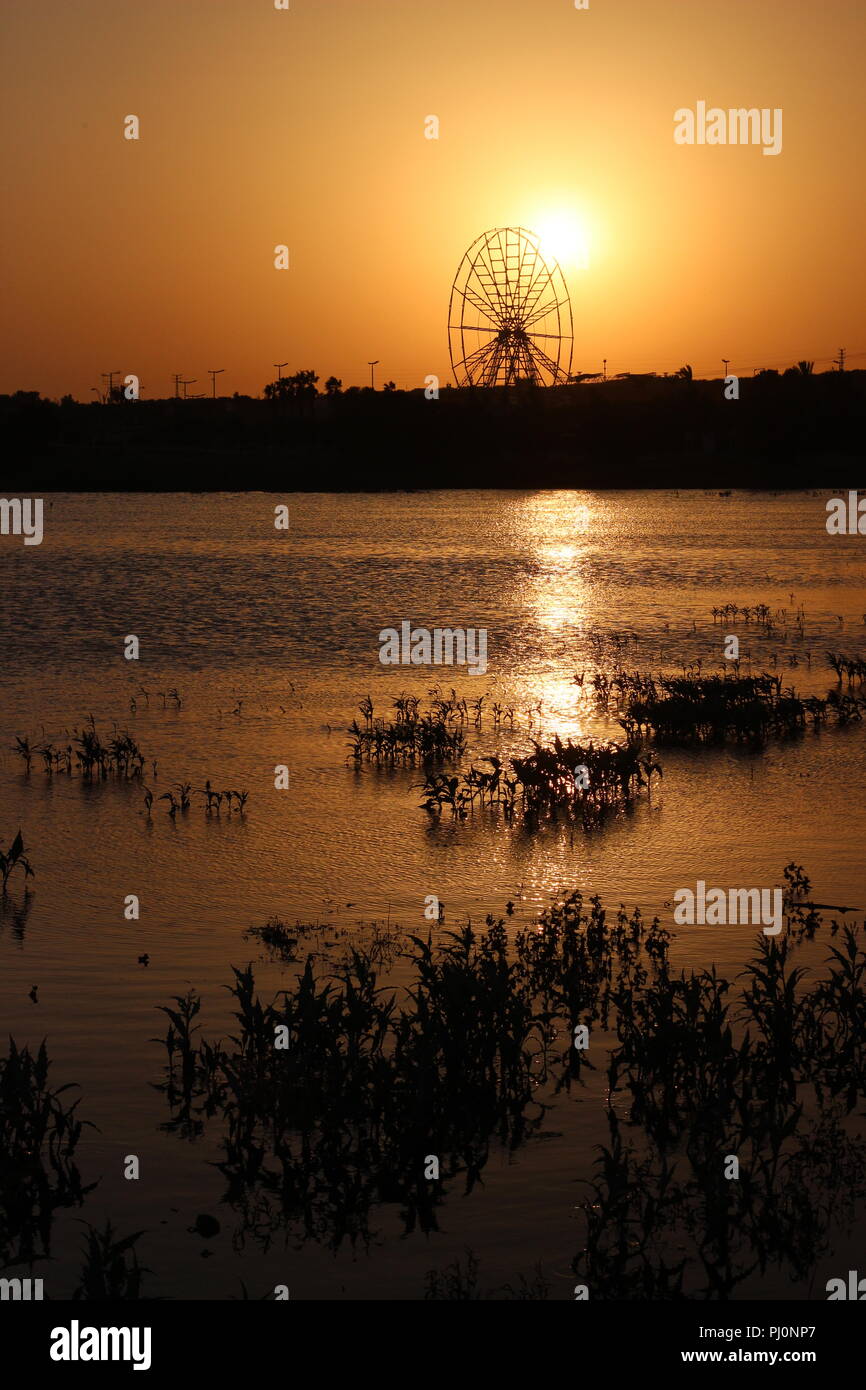 Lake at sunset and amusement park in the background Stock Photo - Alamy