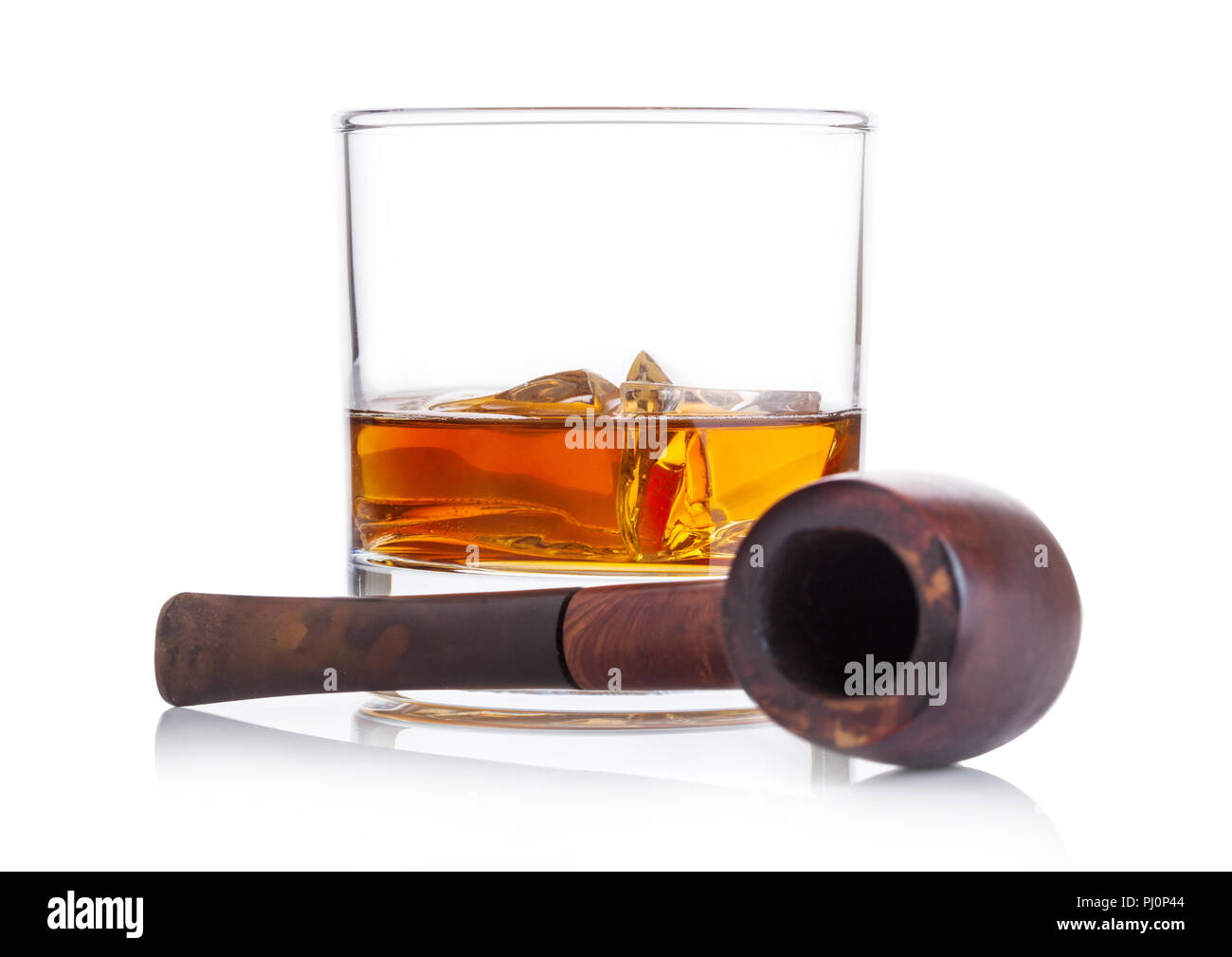 Glass of whiskey with ice cubes and vintage smoking pipe on white ...