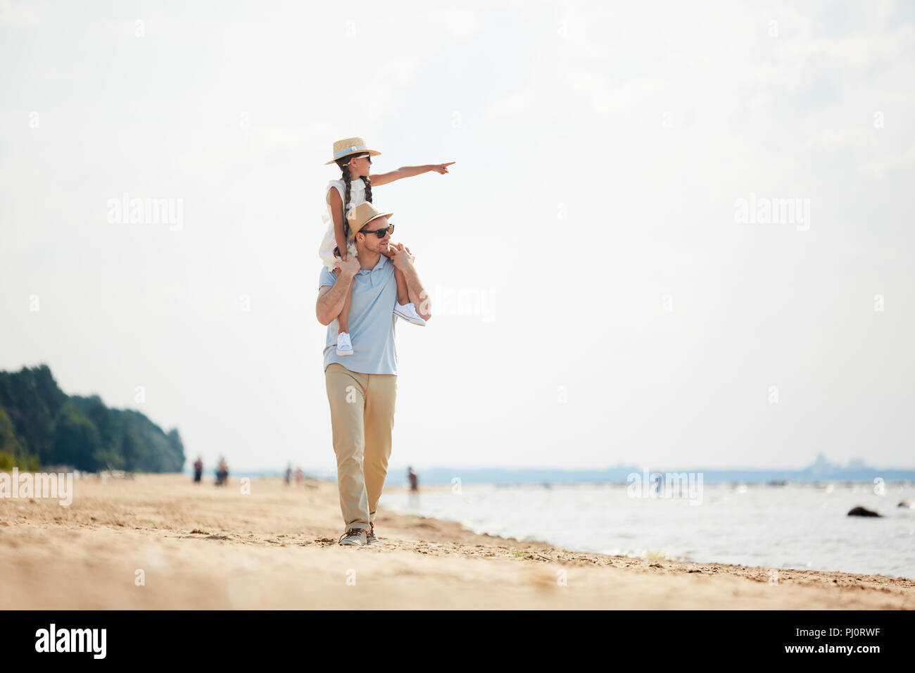Father carrying little daughter on his shoulders on the beach hi-res stock photography and ...
