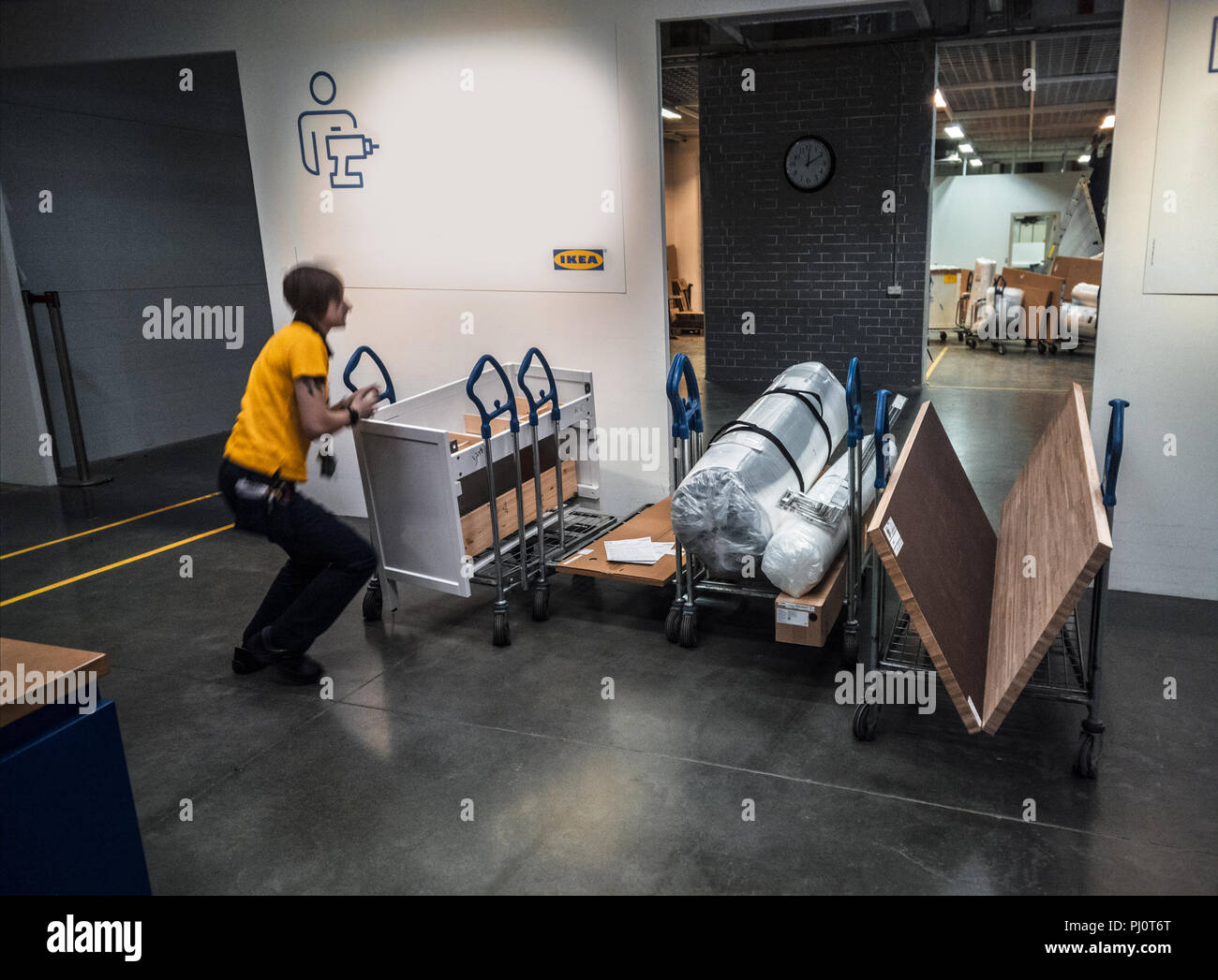 worker pushes a carts with furniture in the Ikea storehouse Stock Photo ...
