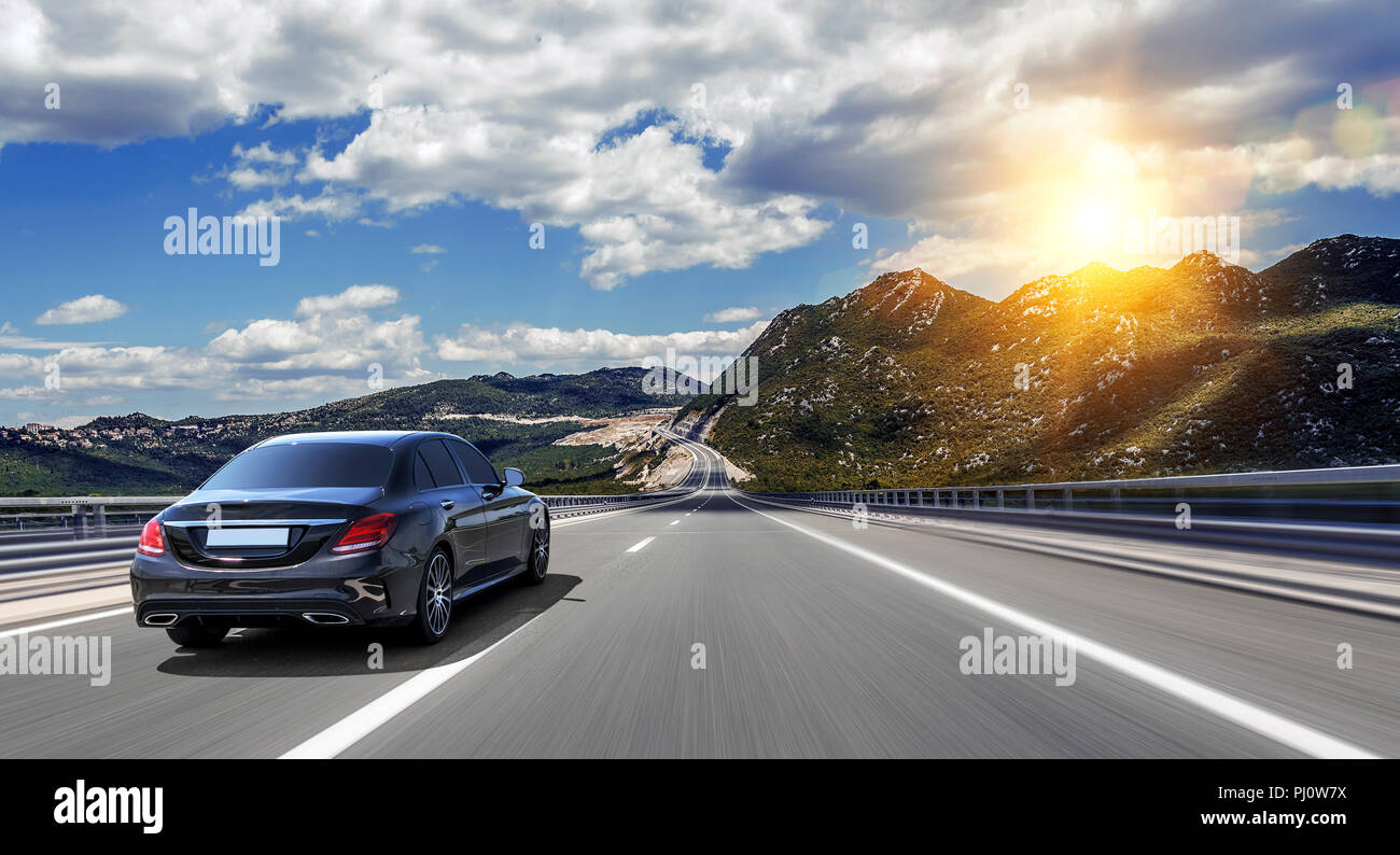 A white car rushing along a high-speed highway in the sun Stock Photo ...