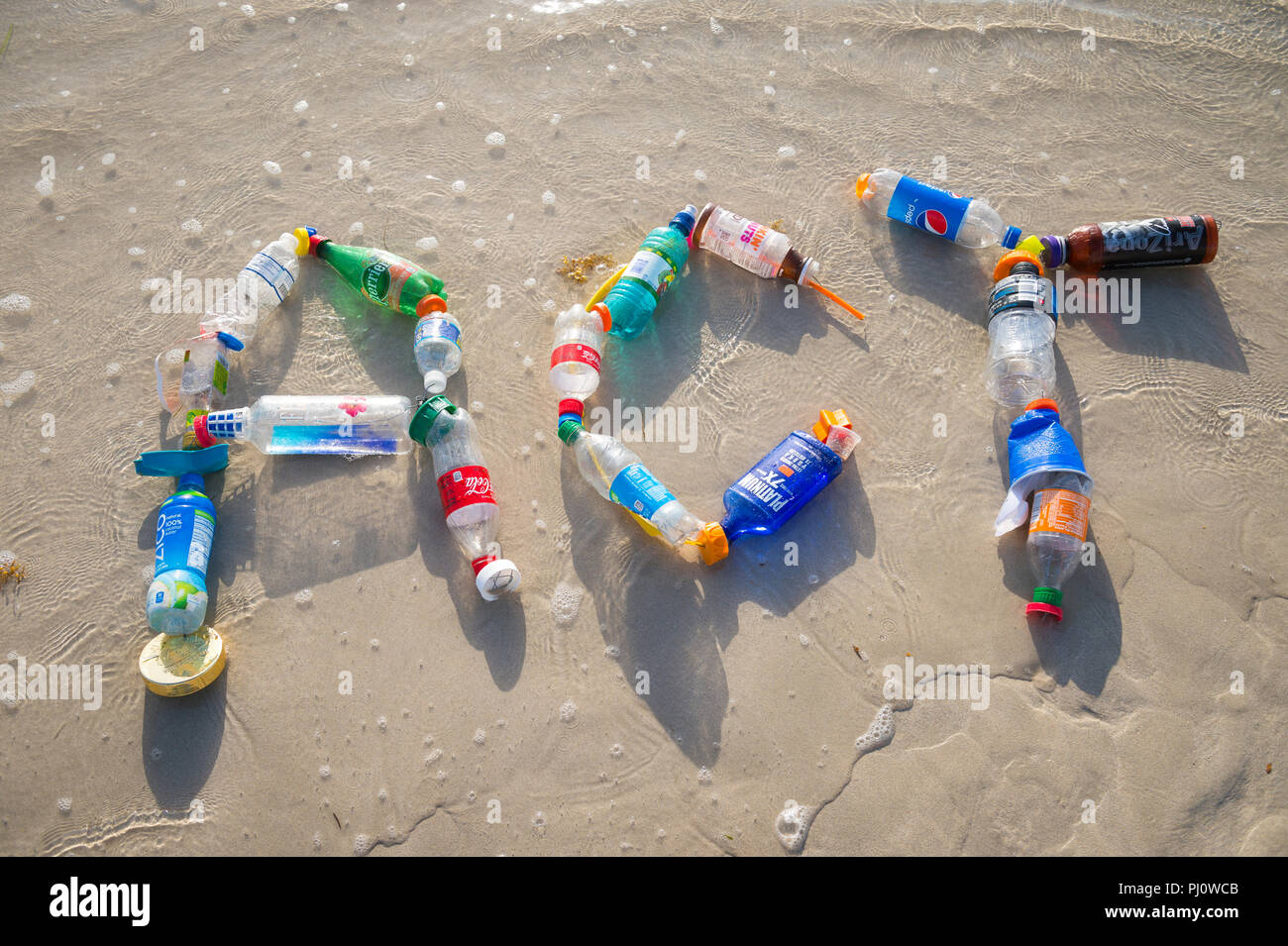 MIAMI - CIRCA JULY, 2018: 'Act' spelled out in the sand using garbage ...