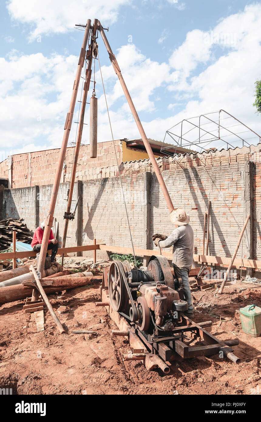 Construction terrain, using a pile driver (bate-estaca) on a tripod to ...