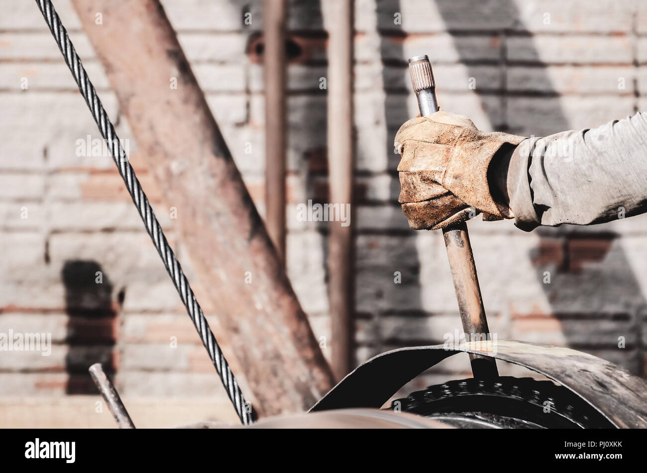 Worker hand pulling the lever of a pile driver (bate-estaca ...