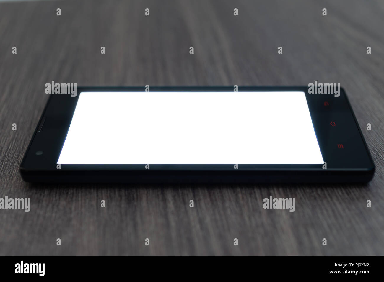 Smartphone white screen lies horizontally on wooden desk table ...