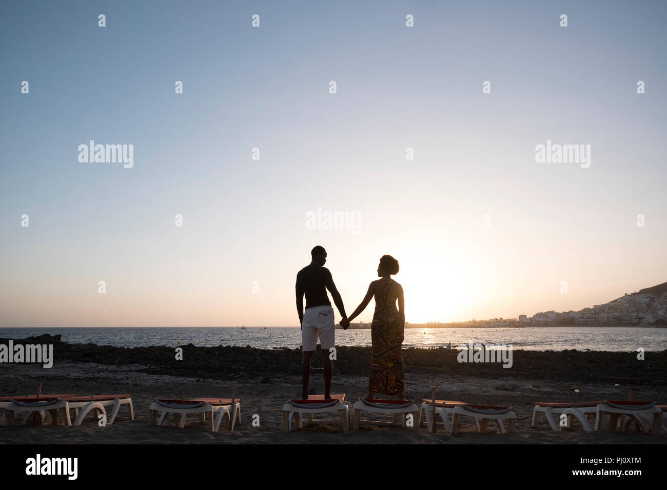 black race african couple enjoying the warm and golden sunset over the ...