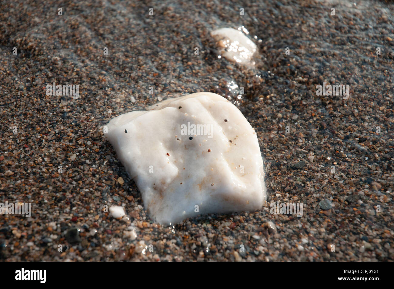 A group of pebbles by the sea shore interacting with the tide Stock ...