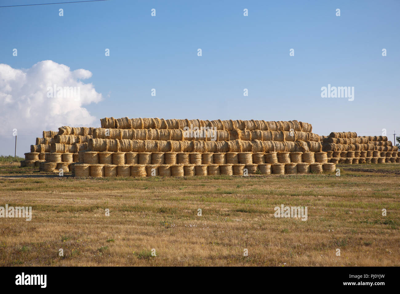 Haystack in agricultural field under the blue sky. Autumn harvest on ...