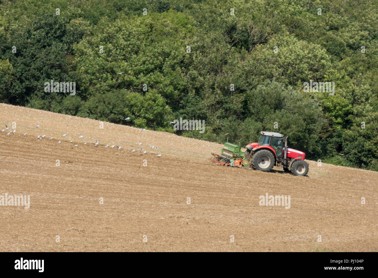 a large tractor pulling a plough or agricultural implement across a ...