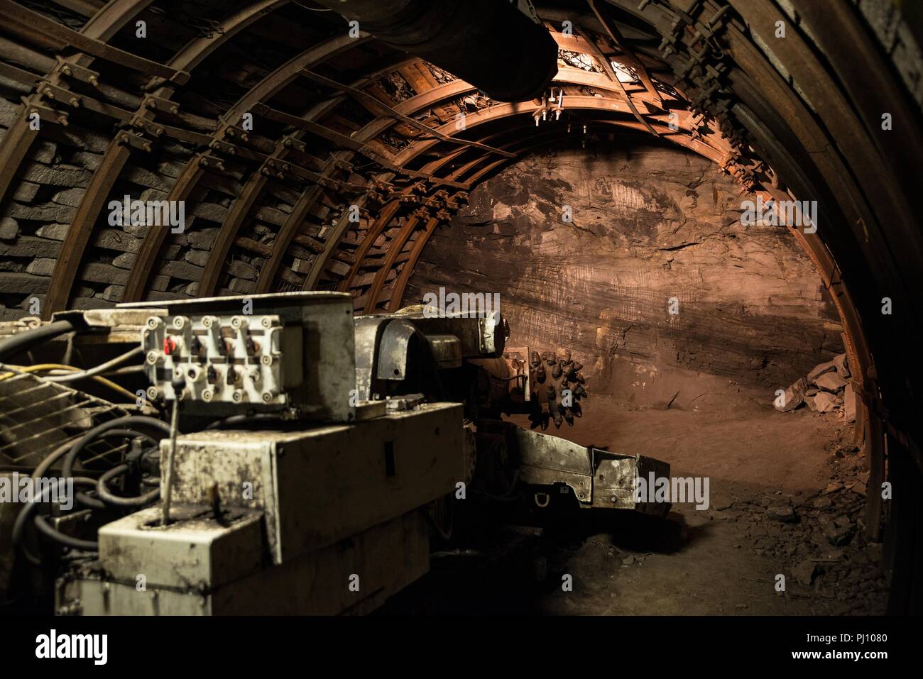 Roadheader drills the tunnel in rock. Underground coal mine Stock Photo ...