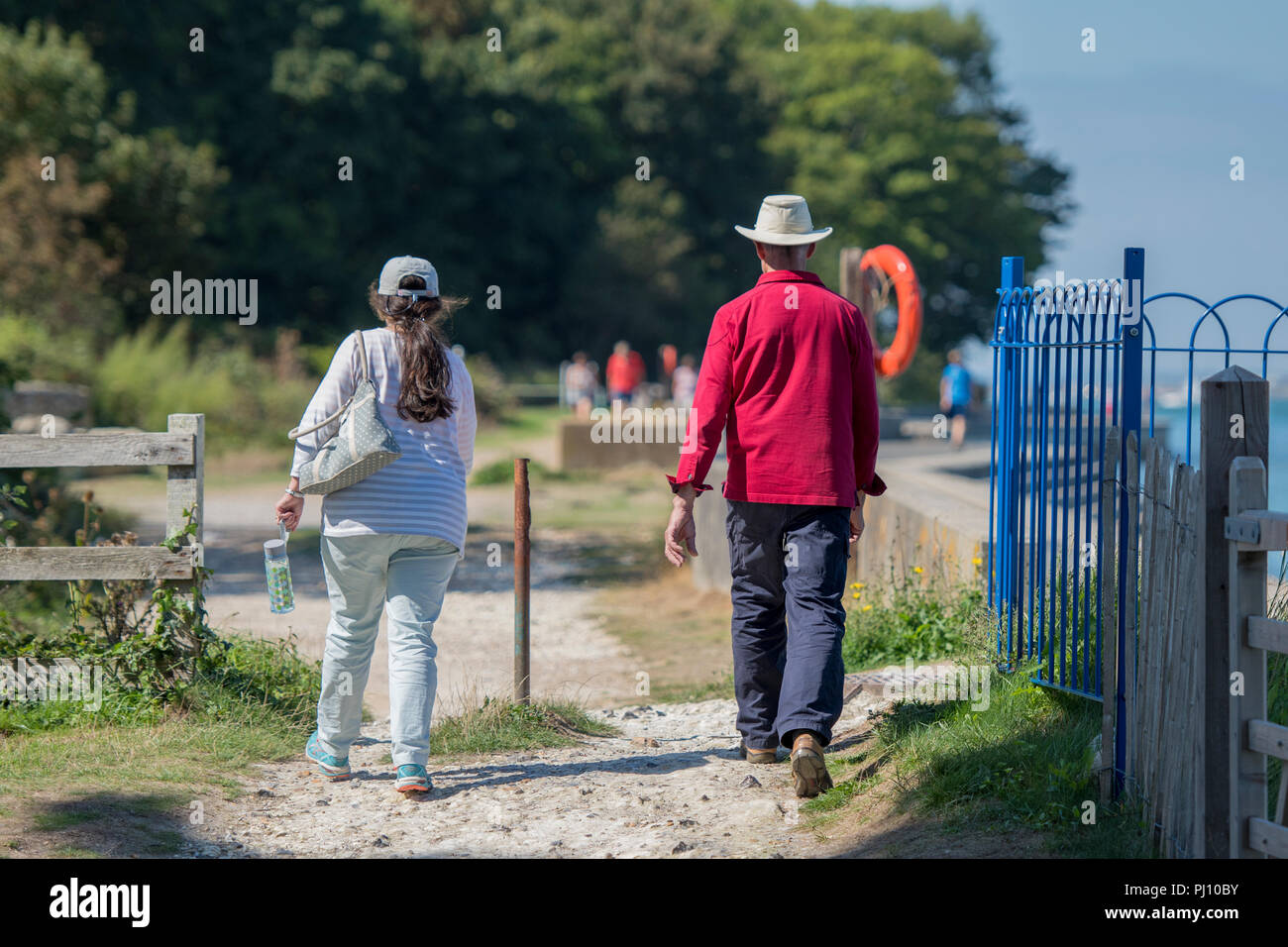 an older middle aged couple on a coastal or countryside walk. walking ...