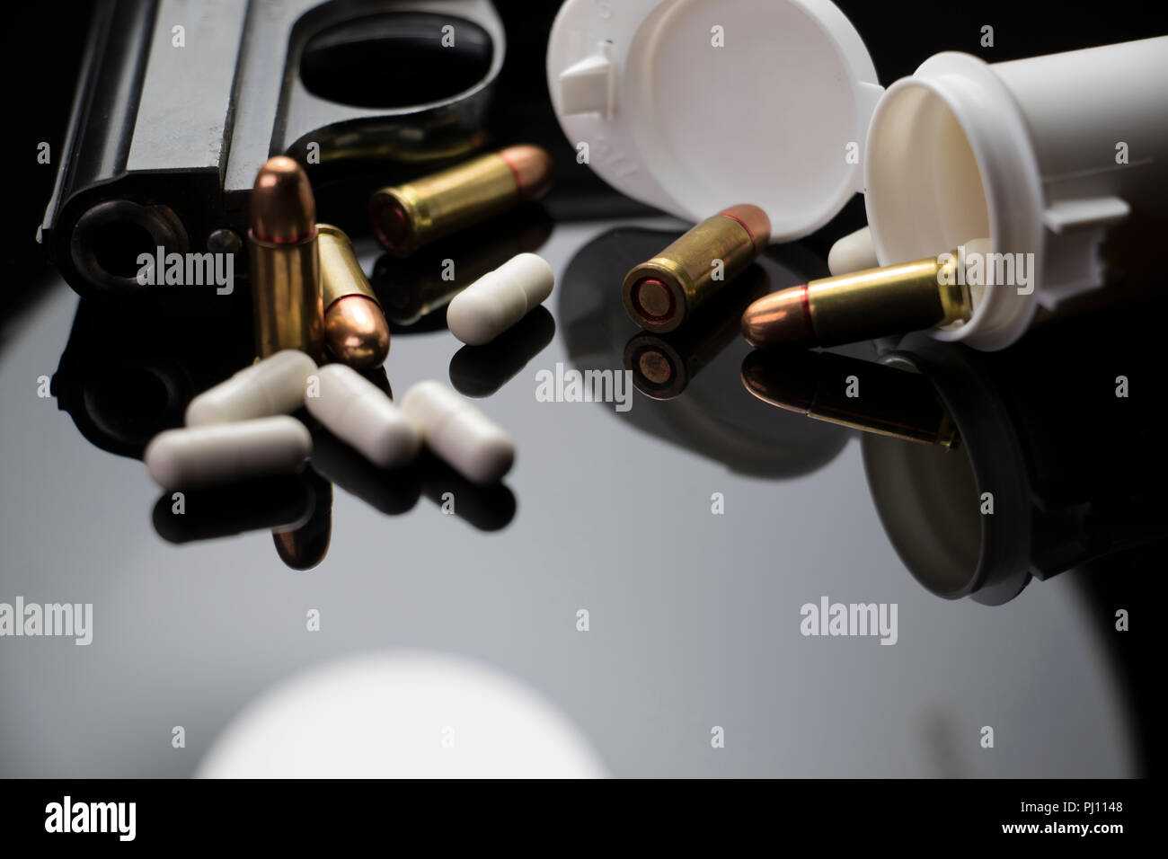 Prescription pills and weapons on a table. Gun bullets and white pill ...