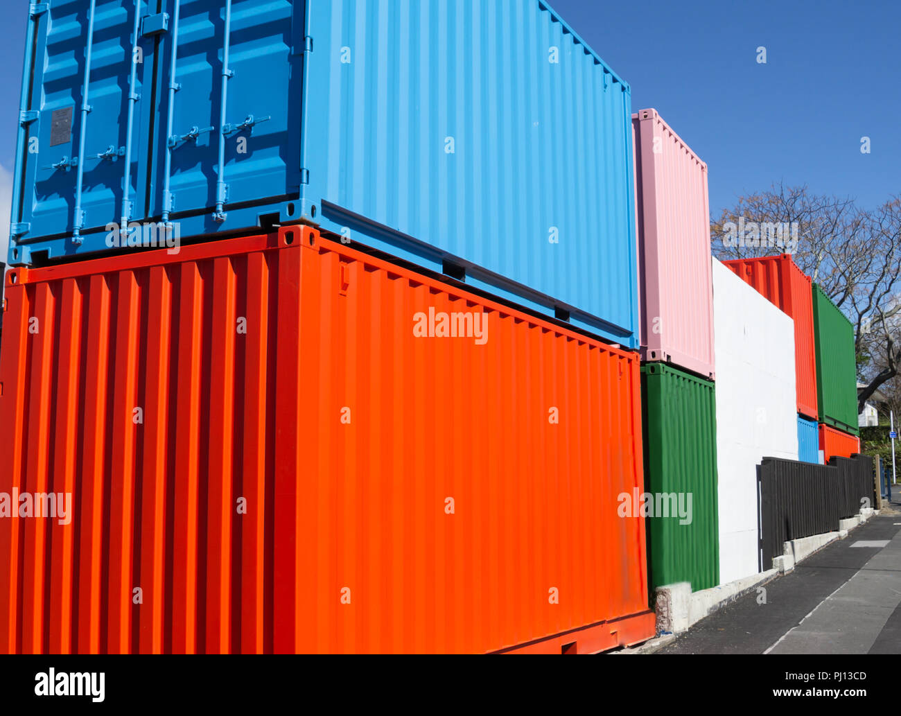 row of disused cargo containers paint in bright colors stacked Stock ...