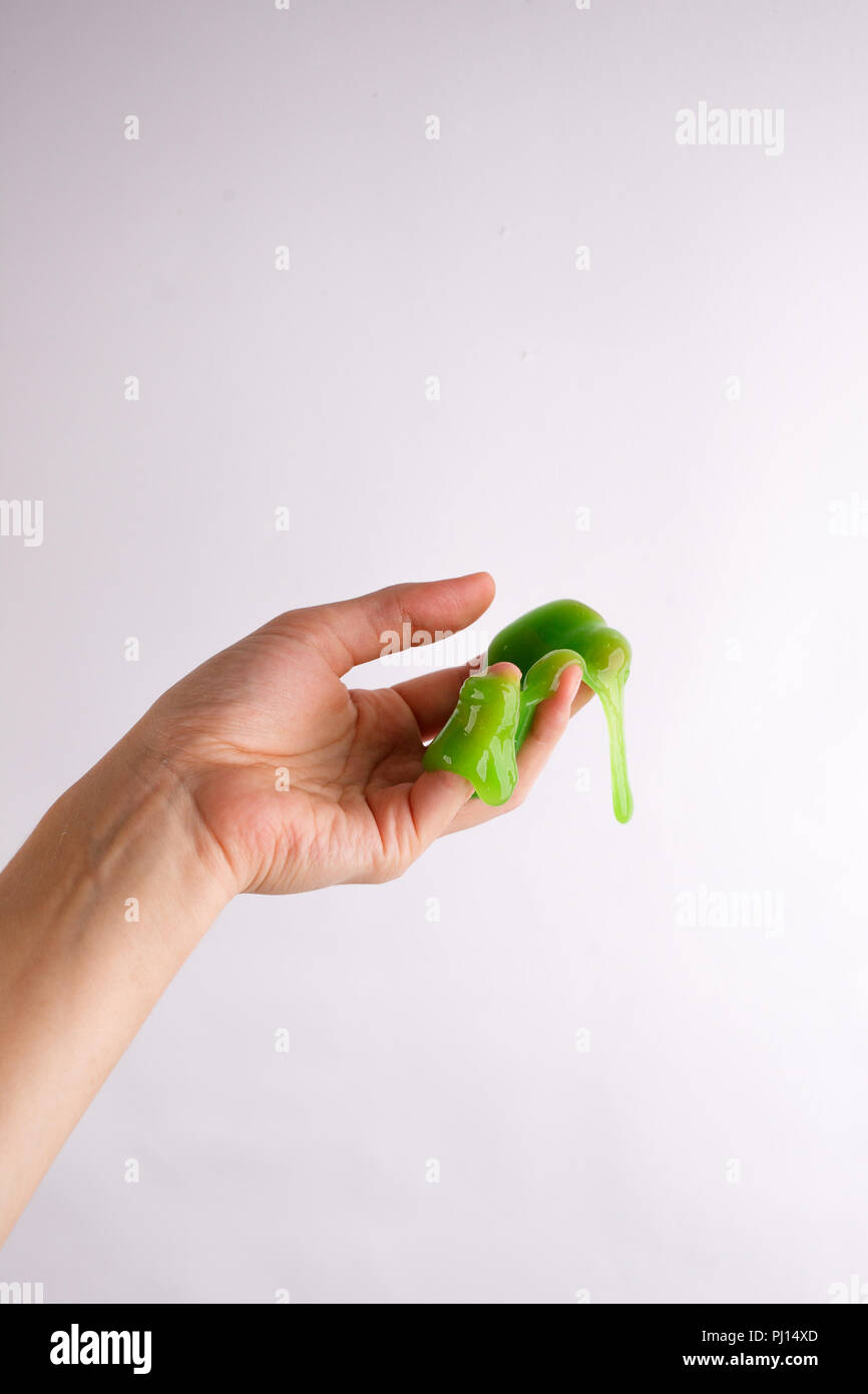 Slime paste green elastic and viscous, woman hand holding slime Stock ...
