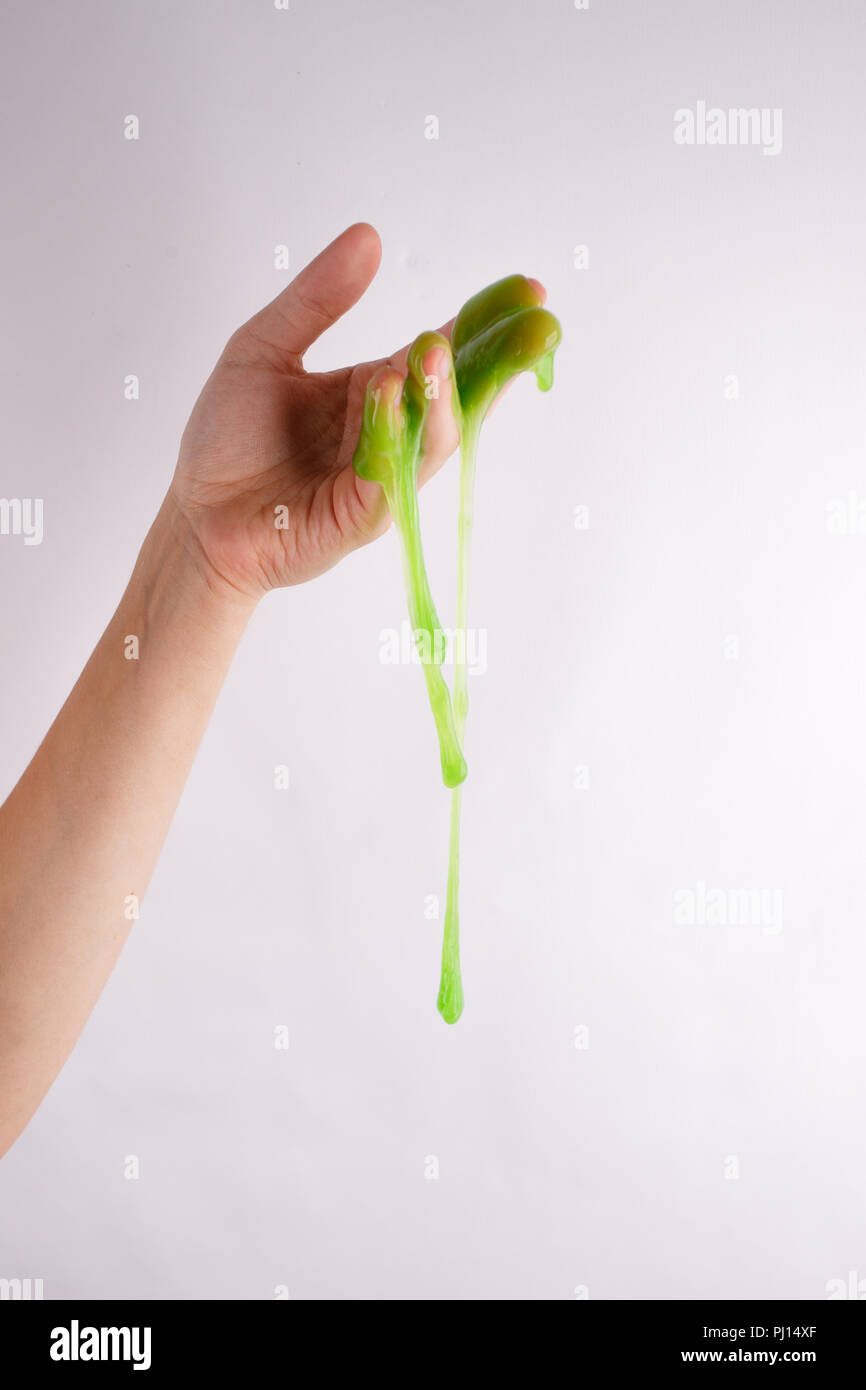 Slime paste green elastic and viscous, woman hand holding slime Stock ...