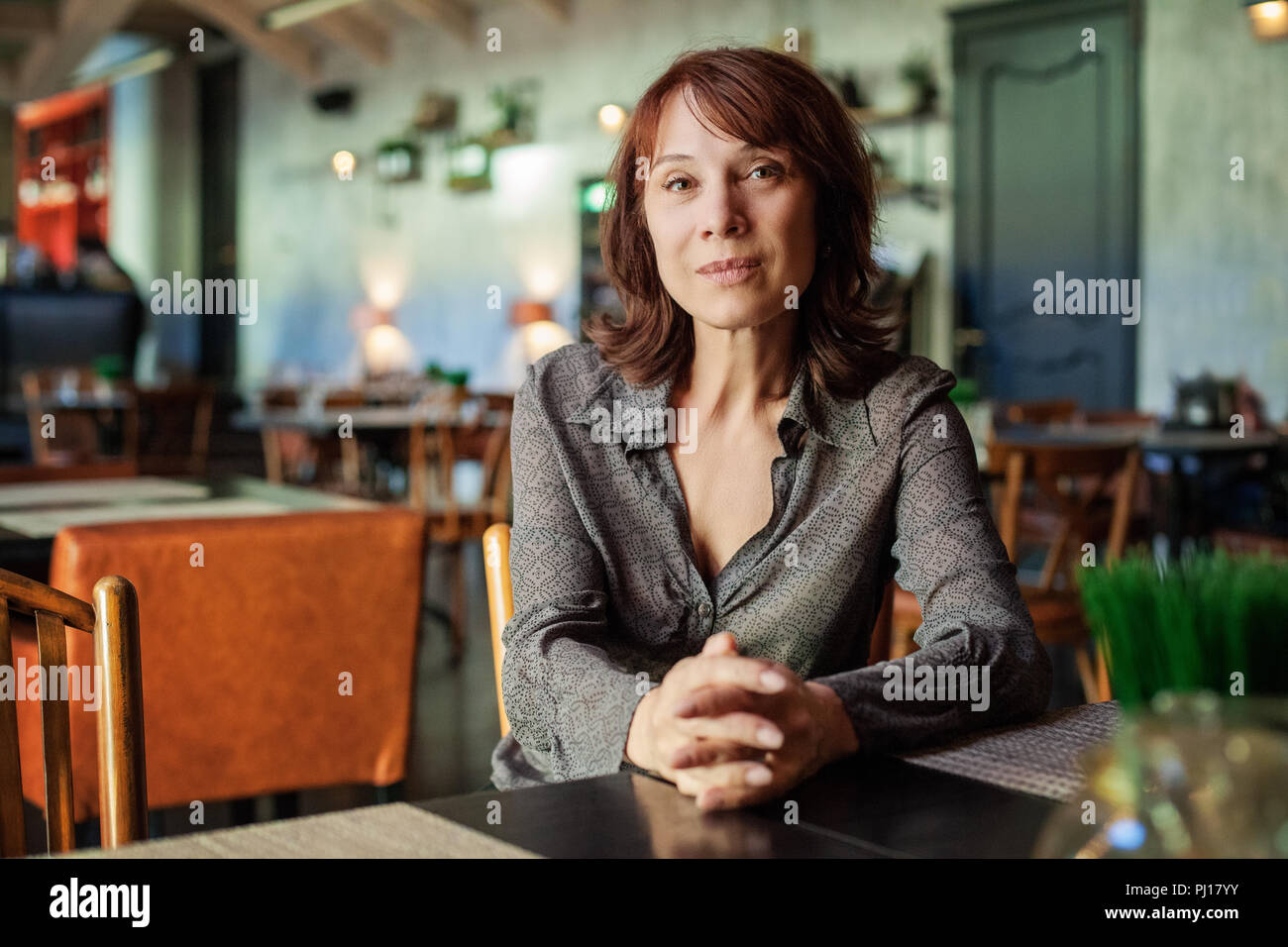 Mature woman sitting in restaurant, portrait Stock Photo - Alamy