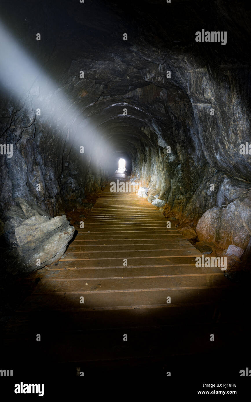 Light from a flashlight shining through a narrow cave in the tow Stock ...