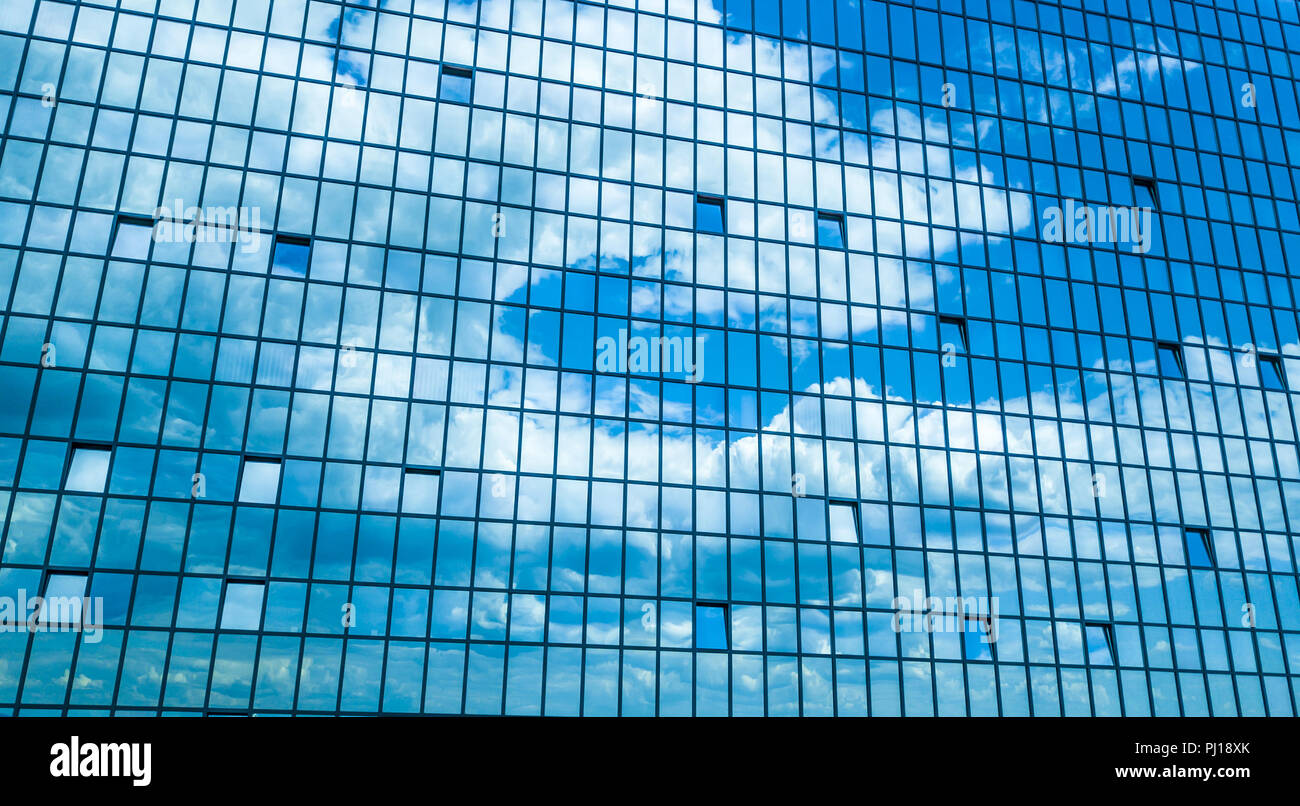 Clouds reflected in windows of modern office building Stock Photo - Alamy