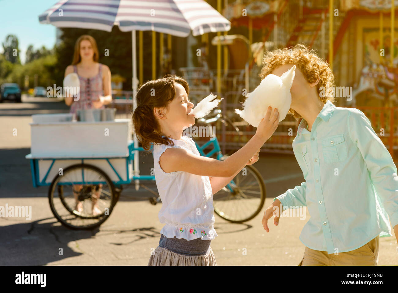 Funny kids eat cotton candy Stock Photo - Alamy