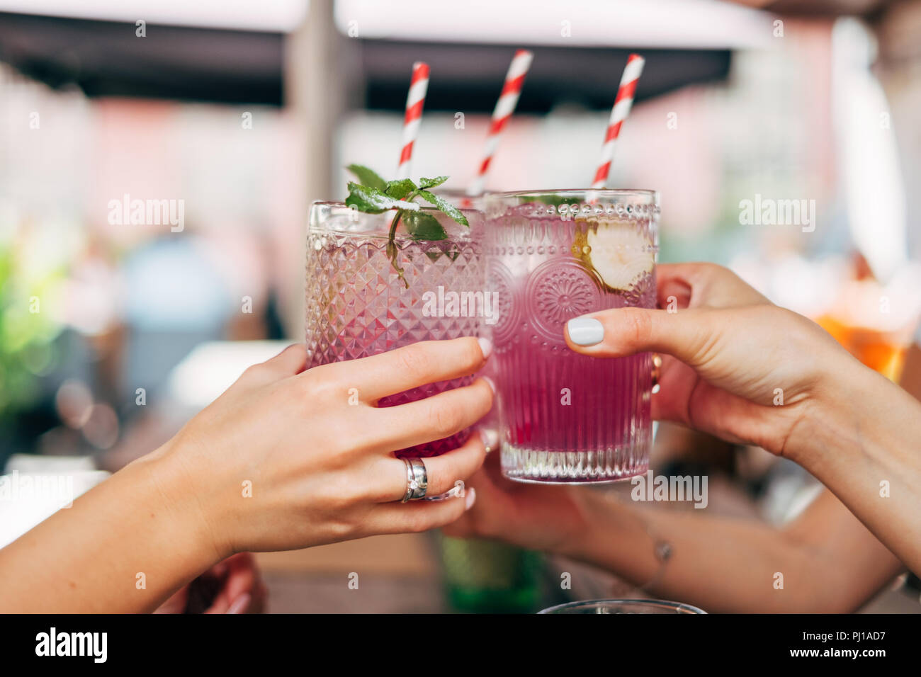 Close-Up of three women toasting with fruit cocktails Stock Photo - Alamy