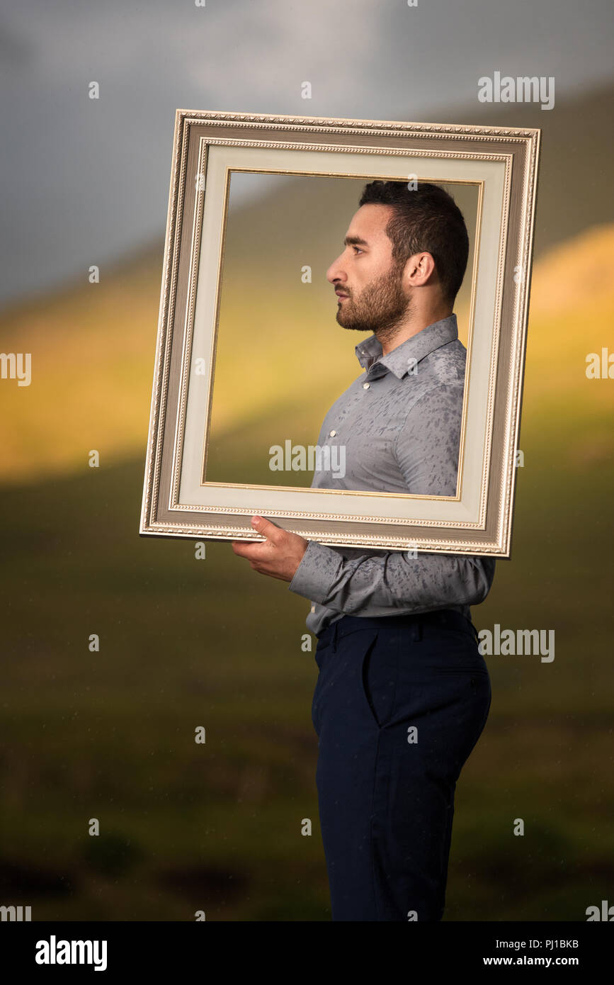 Portrait of a man holding a picture frame Stock Photo - Alamy