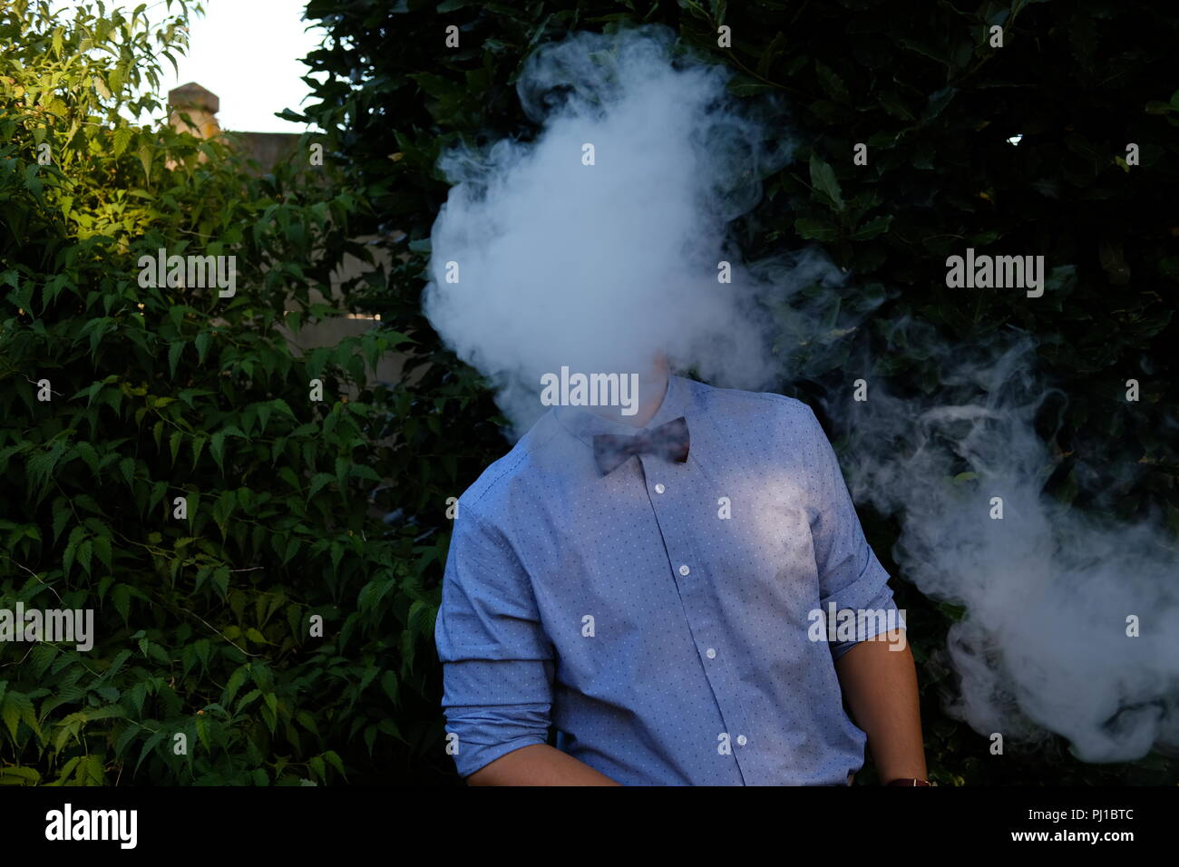 Man standing in the garden with smoke in front of his face Stock Photo ...