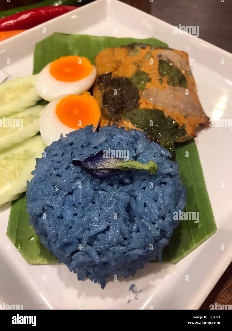 Thai blue rice with egg and cucumber Stock Photo - Alamy