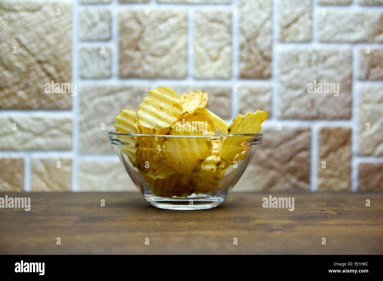Corrugated chips inside a bowl on a wooden table Stock Photo - Alamy