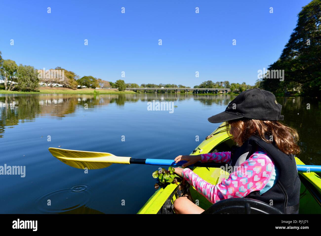 Children paddling in a canoe in beautiful weather, Ross River QLD ...