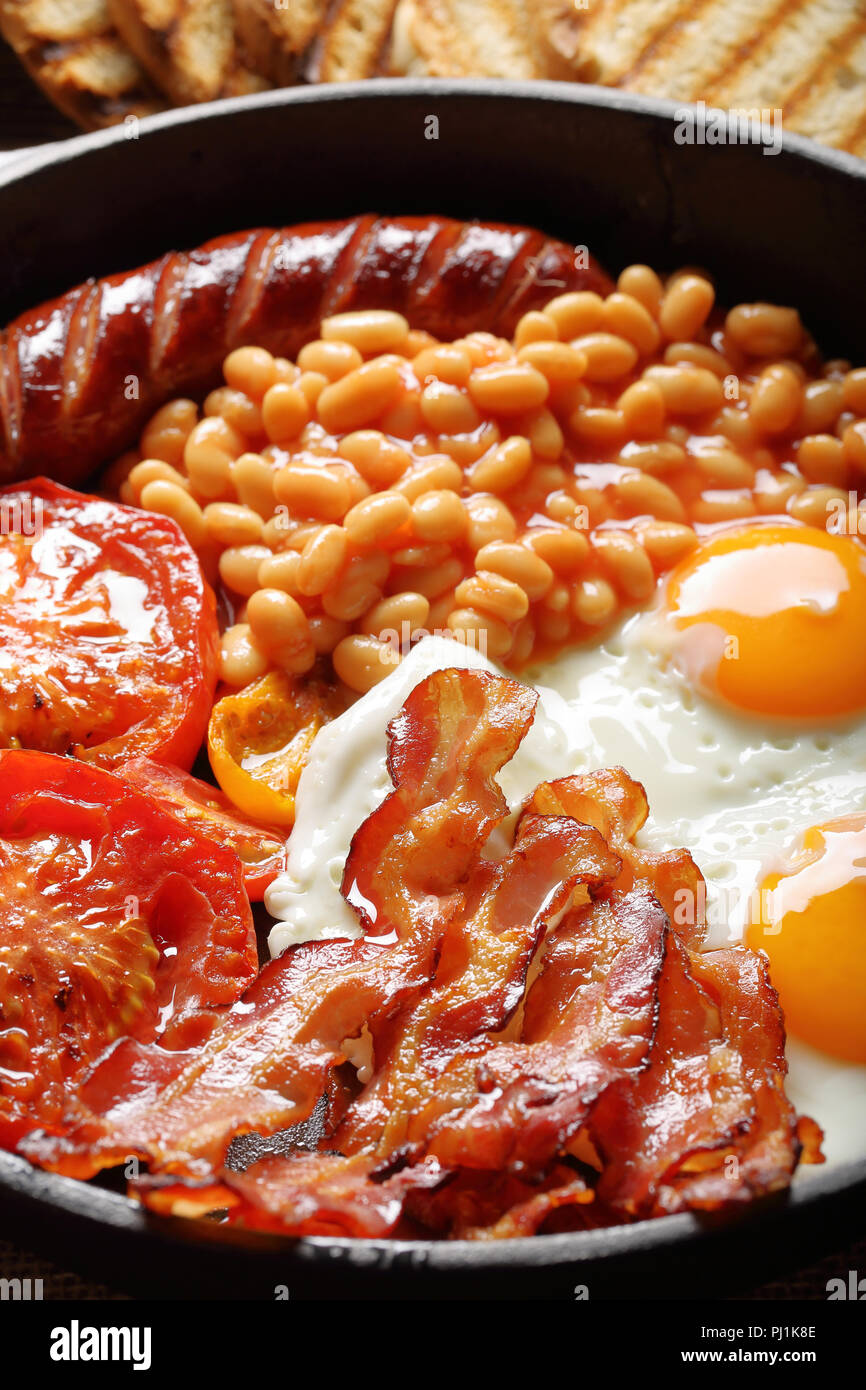 English Breakfast with sausages, grilled tomatoes, egg, bacon and beans ...