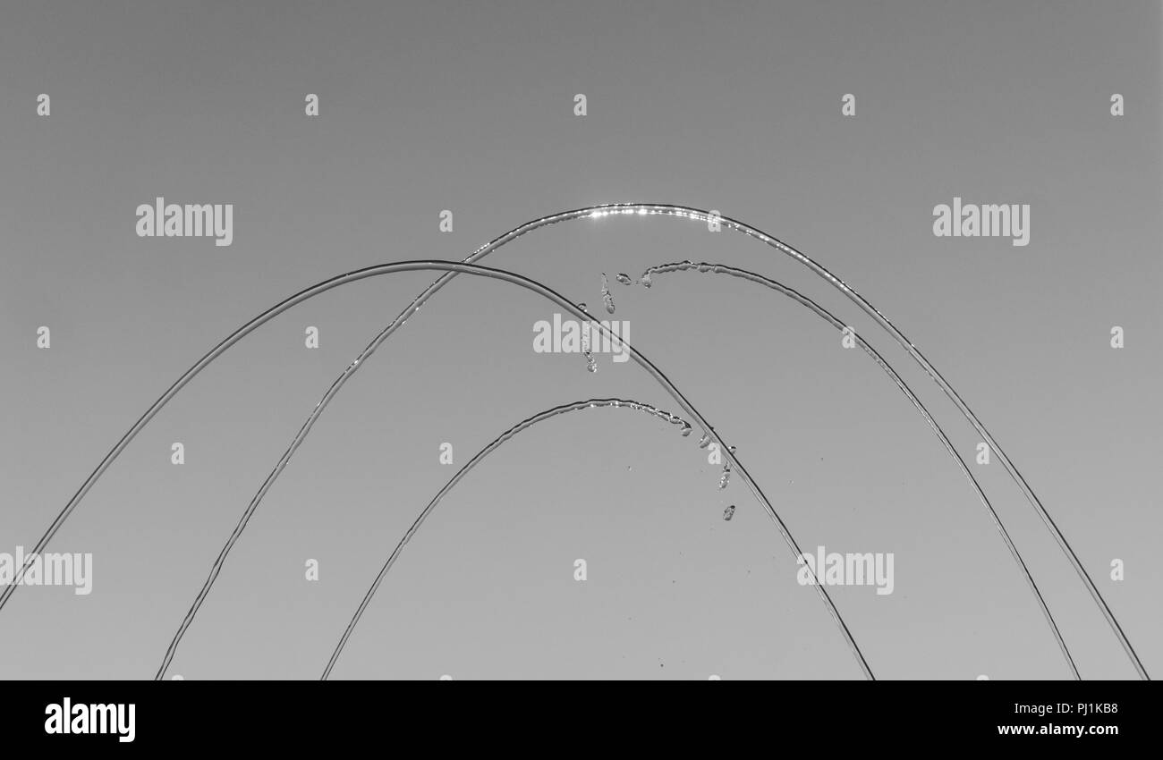 Thin streams and drops of water on a blue background Stock Photo - Alamy