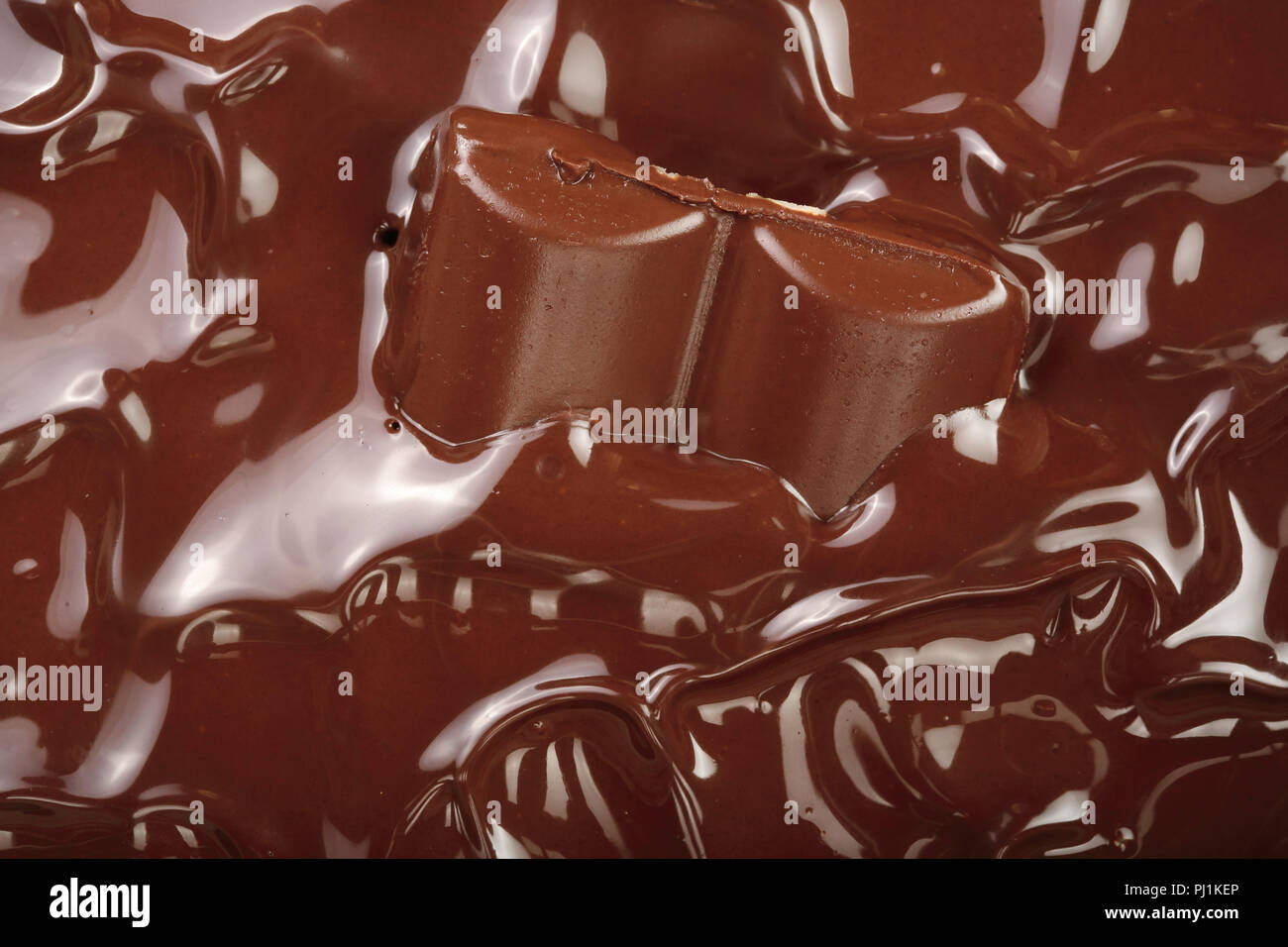 Melted chocolate and pieces of chocolate bar as a background closeup ...