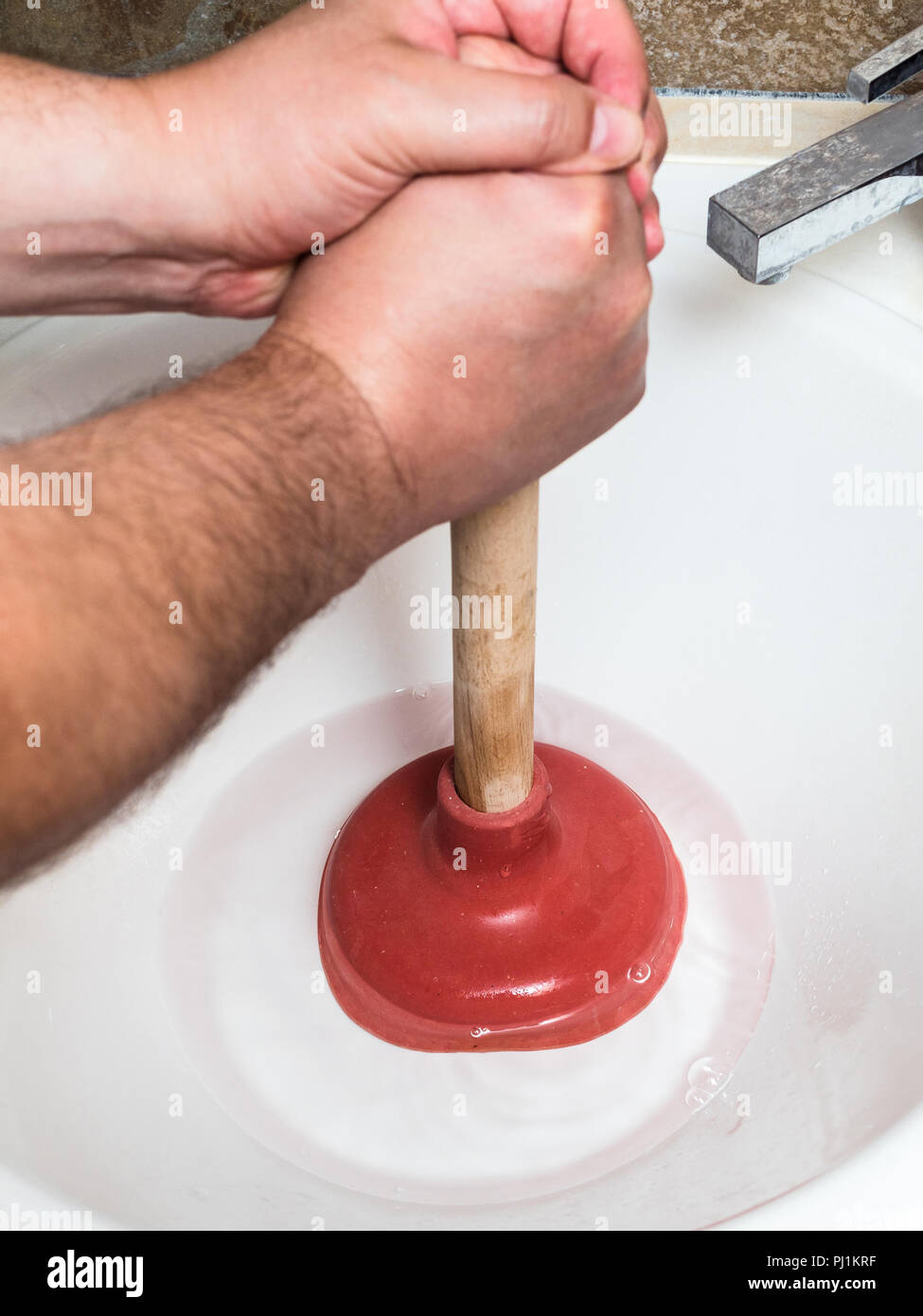 man clears water blockage in sink drain by plunger Stock Photo - Alamy