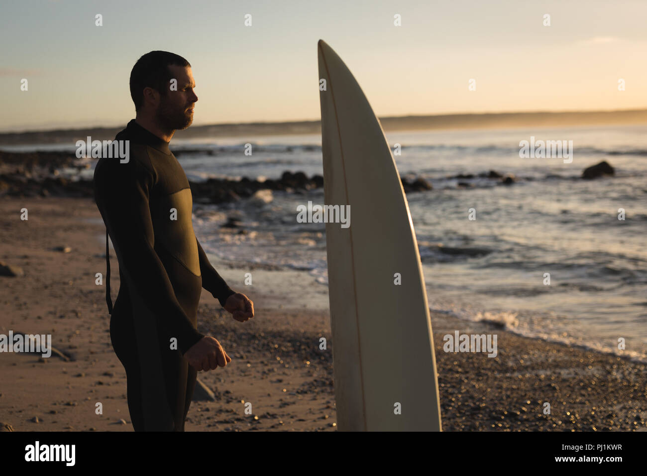 Surfer standing on beach with surfboard hi-res stock photography and ...